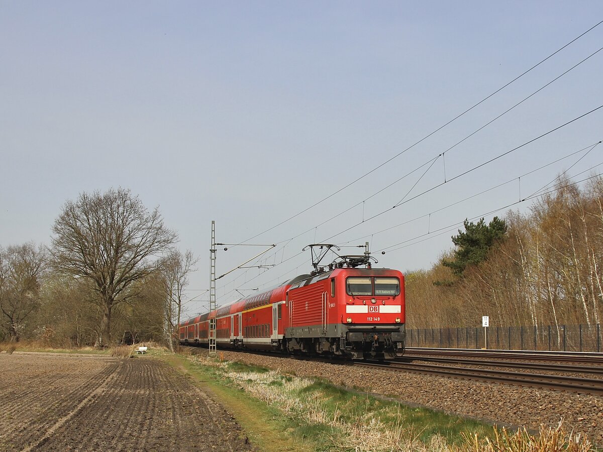 112 149 zieht am 12.04.2022 den RE 70 nach Hamburg Hbf durch Halstenbek - Bahnbilder.de